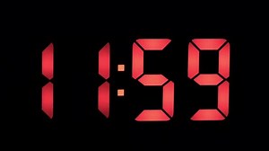Countdown to midnight with a digital clock displaying 1159, indicating the last minute before a new hour or new year begins