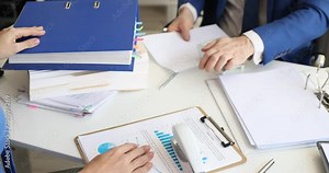 Business man and woman folding documents into folders and sorting them with hole punch 4k movie. Paper work concept