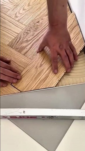 Installing interlocking wooden floor tiles with precision for a stylish and seamless pattern finish