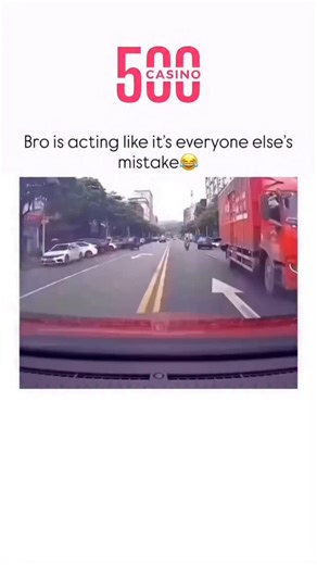 prime on Instagram: "This video is a short dashcam recording showing a traffic incident on a busy, multi-lane city street. The camera perspective is from inside a vehicle, with the red dashboard visible across the bottom of the frame. The view looks straight down a wide urban street lined with parked cars, trees, and buildings. Traffic appears moderate. At the beginning of the clip, a dark-colored sedan can be seen pulling out from the right side of the frame, moving from the curb lane into the 