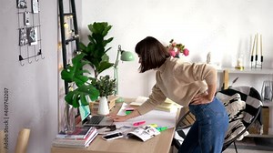 Caucasian female designer creating blueprint sketch enjoying inspiration in coworking,carefree woman with markers drawing and dancing near desktop with modern laptop for browsing media file on website