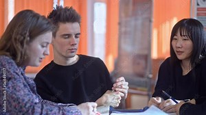 Young creative colleagues are planning design blueprint, holding marker to draw layout. lrrl watching photos on camera screen. architect are busy working on important project.