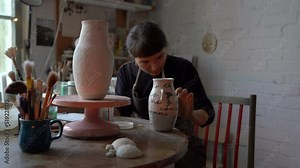 Skilled young female pottery artwork small business owner enjoy new modeling ceramic vase in workroom for craft store. Artistic hobby making porcelain product inspiration in studio. Work for pleasure.
