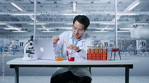 Asian Man Scientist Making Experiment With Test Tube, Typing On A Laptop Then Having A Headache In The Laboratory With Microscope. Working In The Lab Analyzing His Findings Samples Test Tube