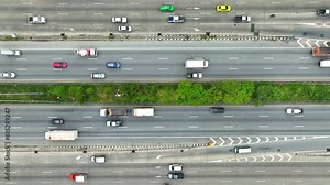 Observing from above, the multi-lane road showcases orderly traffic flow. Cars, a motorbike, and a truck traverse delineated lanes, illustrating the efficient utilization of infrastructure.