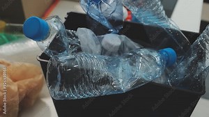 Garbage separation concept. Female hands separate paper and plastic into separate containers in the kitchen at home. Waste segregation, waste sorting, waste recycle.