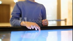 A child of primary school age use touch screen. The boy is exploring information about the exhibition exhibits on an interactive touch screen display