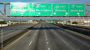 Drone shot toward freeway signs at the closed Interstate 10 in sunny Los Angeles