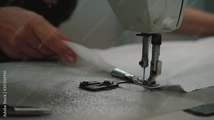 A seamstress sews on a sewing machine hems a fabric with a nice pattern for bed linen Stock Video