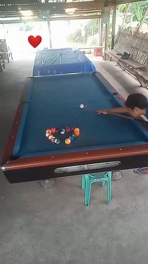 Young Boy Enjoys Playing Pool on Blue Table