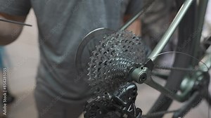 Man bicycle mechanic at work in the workshop. Velomechanic fixes and adjusts brake mechanism on bike in repair station. Bike shop technician setting rear hydraulic brake on Gravel bike.
