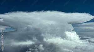 Pilot POV flying in a stormy sky with a massive cumulonimbus storm cloud ahead with its perfect anvil shape. Immersive view from cockpit. 4K