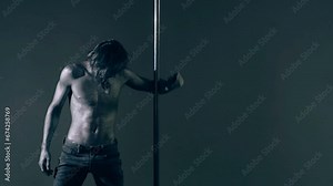 Pole dancer. Guy does gymnastic exercises on pole dance. Pole dancing for slim fitness body. Flexibility. Pole dance. Pylon dancing strength, flexibility, and grace. Strip muscular man dancer.