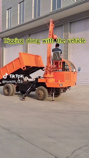 Excavator Digging Alongside Tipping Bucket Dump Truck