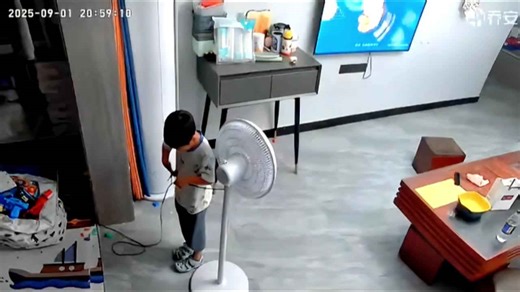 Young boy cuts live fan power cord with scissors sending sparks flying