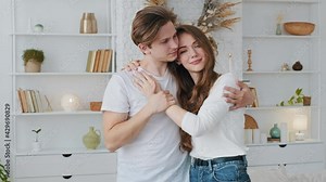 Caucasian couple married man and woman guy and girl embracing stand at new home together, husband and wife boyfriend and girlfriend hugging cuddling enjoy intimacy tender love romantic relationship