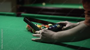 Man with billiard balls in triangle in a pool table. Games and sports