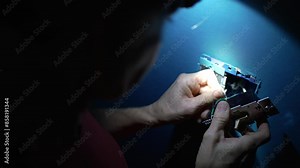 Over the shoulder view of woman putting wire nuts on electrical wires installing a light switch in a home improvement project.