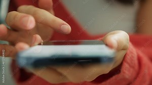 Cinematic close up Girl scrolling pages in mobile app on cell phone device. Browsing movie video on internet library to watch film online. Slow motion woman fingers touching modern smartphone screen