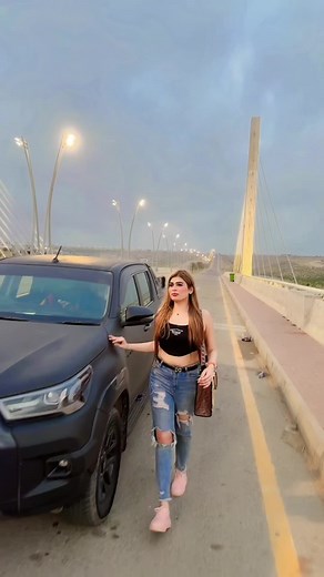 Stylish Pose by a Black Toyota SUV on a Bridge