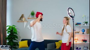 Modern couple very attractive at home in the living room using a smart phone to recording a live stream using a light ring they have a funny time together
