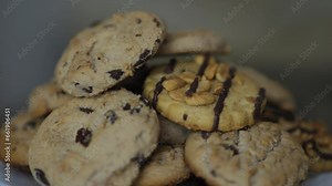 Close-up of Group of Assorted Cookies. Chocolate Chip, Oatmeal Raisin, White Chocolate Fill Frame. Cookies With Pieces of Chocolate, Rotation. Junk Food Diabetes Carbohydrates Unhealthy Diet.