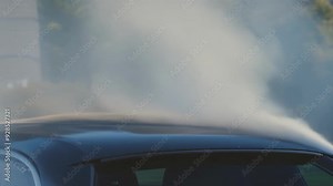 Heavy smoke rising up and enveloping the entire car as the engine starts up with a loud rumble.