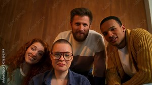 diverse friends sit on sofa chatting at home, have video call using laptop web camera, listening and nodding. looks cheerful and joyful, smiling and laughing, looking at camera Stock Video