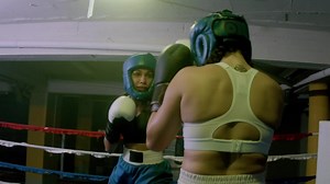 Free stock video - Two female boxers in helmets and boxing gloves training in ring