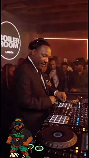 🎧 Prompt: “MLK Jr as a DJ in a London Dance Club” Ultra-realistic cinematic video of Dr. Martin Luther King Jr. as a modern DJ performing at an underground London dance club. He wears sleek black headphones and a stylish fitted suit with glowing accents, standing behind futuristic turntables with holographic vinyls. The club is packed with a diverse crowd dancing under flashing neon lights, strobe beams, and fog. The walls display powerful quotes about unity and freedom pulsing in sync with the