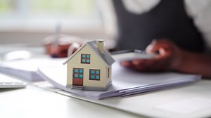 clip-1095410135-person-hand-doing-property-tax-calculation-using