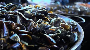 Mussels in the shell. Cook fries mussels in a large frying pan. Seafood. Seafood delicacies. Clams. Fish restaurant. Vitamins, minerals and trace elements. Iron, manganese, phosphorus, potassium, zinc