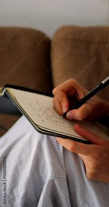 New Year Goals 2025. Woman's Hand Writing in Notebook Goals List. Journaling Concept. 4K, Vertical