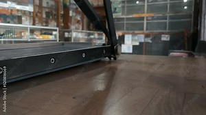 A man is cutting paper using a manual paper cutter at his desk