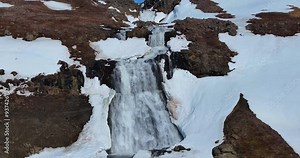 The aerial view revealed a breathtaking tableau of a thundering waterfall, its icy waters plunging into a snowy chasm, surrounded by a landscape of unbroken white, Rjukanda Waterfall.