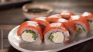 Eating Sushi with chopsticks. Philadelphia sushi roll japanese food in restaurant. Sushi roll with salmon, vegetables, soy sauce, close up. Japan menu