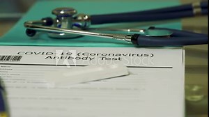 Scene moves right across a form and finger-stick antibody test kit used to quickly determine if antibodies are present in whole blood due past or recent exposure to COVID19.