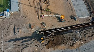 Batumi, Georgia - July 5, 2024:Construction workers install deep trench shoring system under sunny sky. Heavy machinery, including excavators and cranes, supports project on construction site