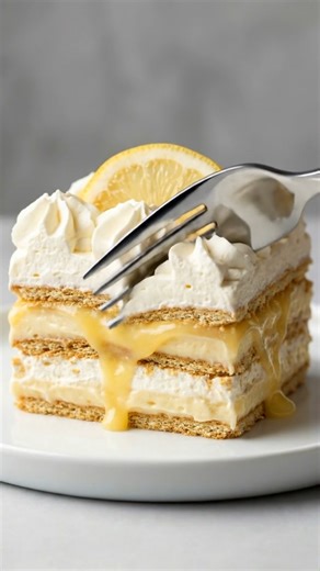 🍪 No-Bake Lemon Eclair Cake | The Refreshing, Creamy Layered Dream There is nothing quite like a no-bake dessert that tastes like it came straight from an expensive bakery case. This no-bake lemon eclair cake is the perfect bright, zesty treat for a sunny weekend with the family or a cozy backyard gathering. Yield: 12-15 generous slices Ingredients: 2 sleeves Honey graham crackers 2 boxes (3.4 oz each) Instant vanilla pudding mix 1 jar (10 oz) High-quality lemon curd 3 cups Whole milk 1 contain