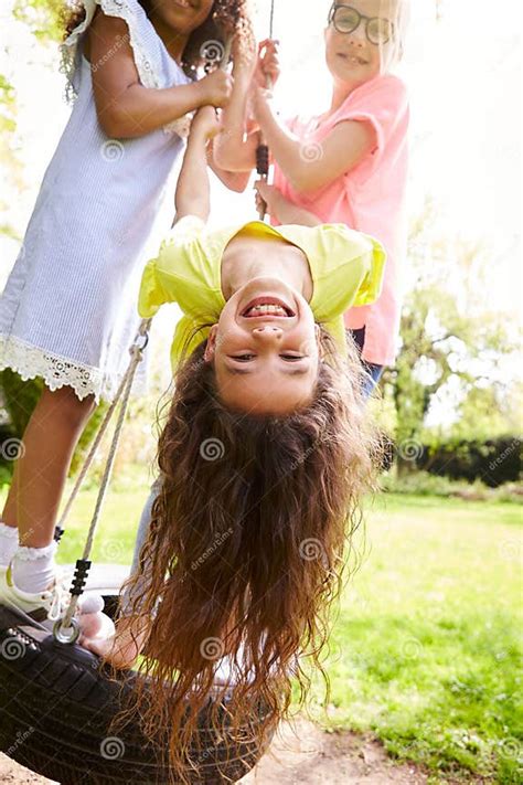 Group Of Girls Having Fun With Friends Playing On Tire Swing In Garden Stock Image Image Of
