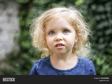 Girl With Curly Blonde Hair And Blue Eyes
