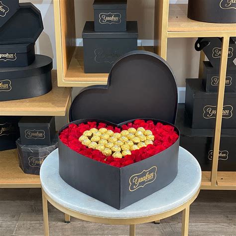 Caja de corazon negra con 65 rosas rojas en caja corazón ferrero