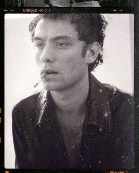 An Old Black And White Photo Of A Man With Curly Hair Wearing A Leather
