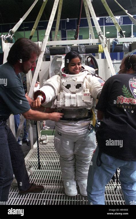 Two Men Standing Next To An Astronaut In Front Of A Ferris Wheel