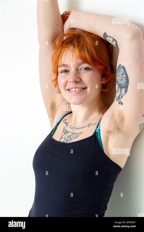 A Beautiful Woman In Her Mid Twenties With Tattoos And Unshaved Armpits With Her Arms Raised