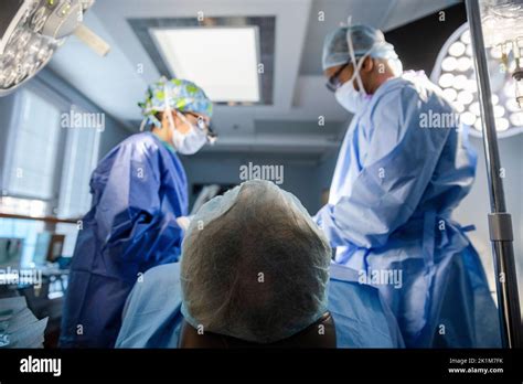 Surgeons Performing Surgery On Patient In Operating Room Stock Photo
