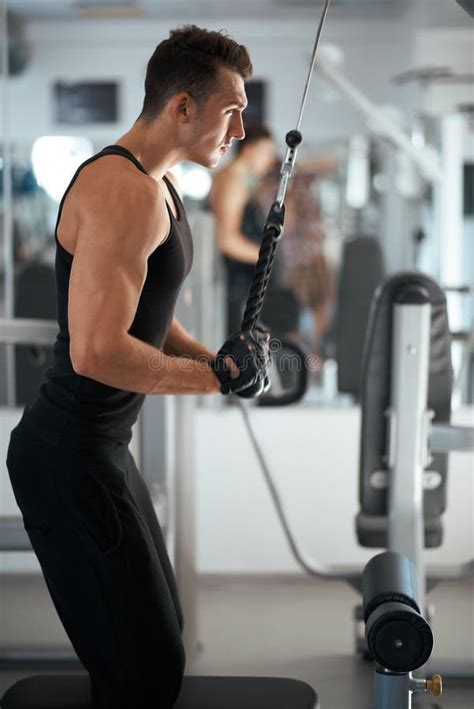 Homem Que Exercita No Instrutor Para Os Músculos Do Tríceps Foto de