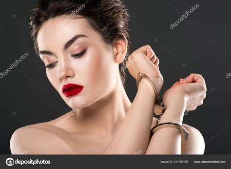 Jeune Femme Nue Sensuelle Menottée Isolée Sur Gris image libre de droit