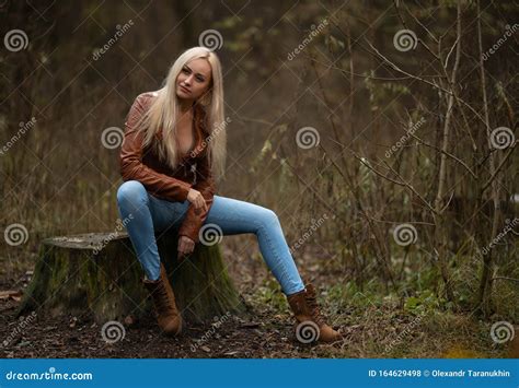 Beautiful Blonde Woman Posing Outdoor In The Autumn Forest Stock Photo