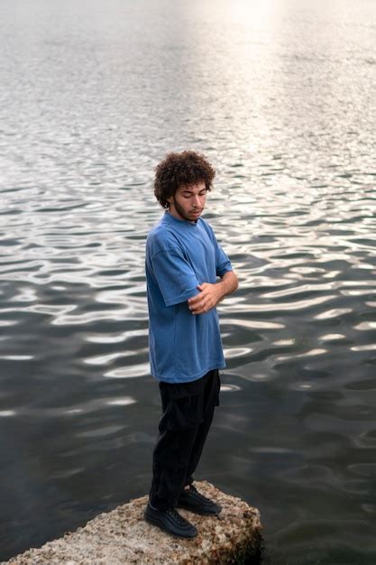 Homem Triste E Contemplativo Sentado Beira Do Lago Foto Premium